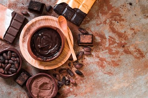 Темные шоколадные батончики с какао-бобами на деревянном столе ...