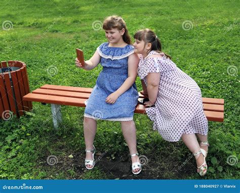 Two Chubby Happy Little Girls with Interest Communicate with Someone on ...