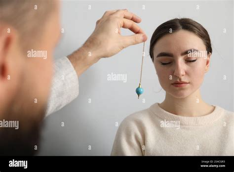 Psychologist using pendulum while working with patient during hypnosis ...