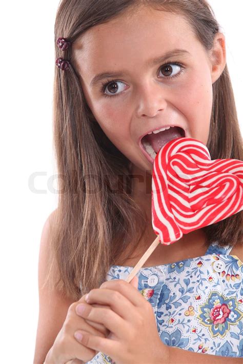Mädchen einen Herz-Lutscher lecken | Stock Bild | Colourbox