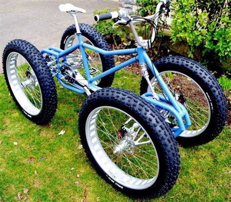 a blue and white bike sitting on top of green grass next to a bush in ...