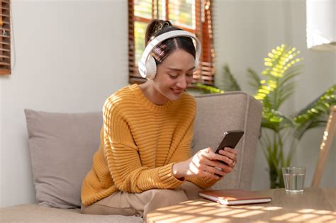Wanita Muda Asia Yang Lucu Mengenakan Headphone Duduk Di Sofa Dan ...