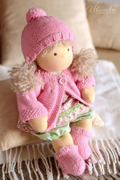 a small doll sitting on top of a pillow