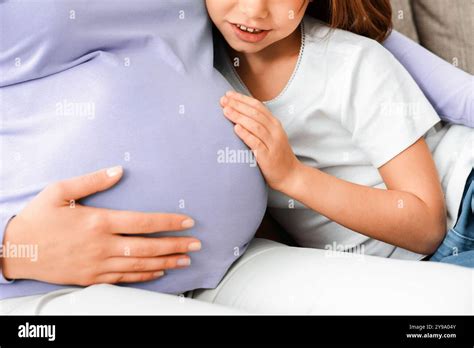 Excited little girl touching her pregnant mom's belly Stock Photo - Alamy