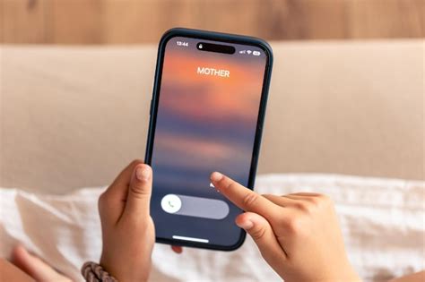 Смартфон в руках ребенка с входящим звонком матери на экране ...