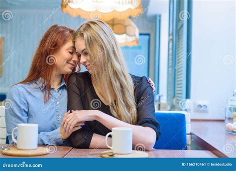Same-sex Relationships. Happy Lesbian Couple Sitting in a Cafe. Girls Gently Hold Hands and ...